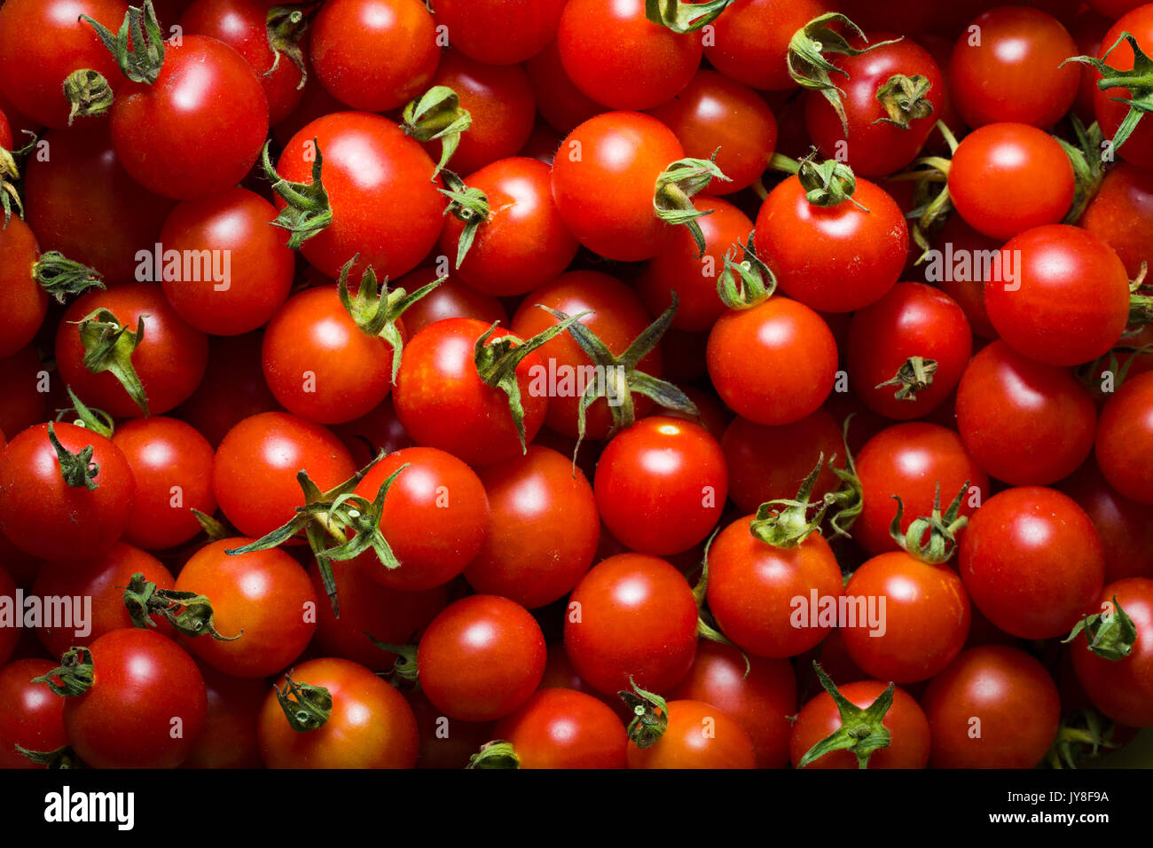 Little red cherry tomatoes nature background Stock Photo - Alamy