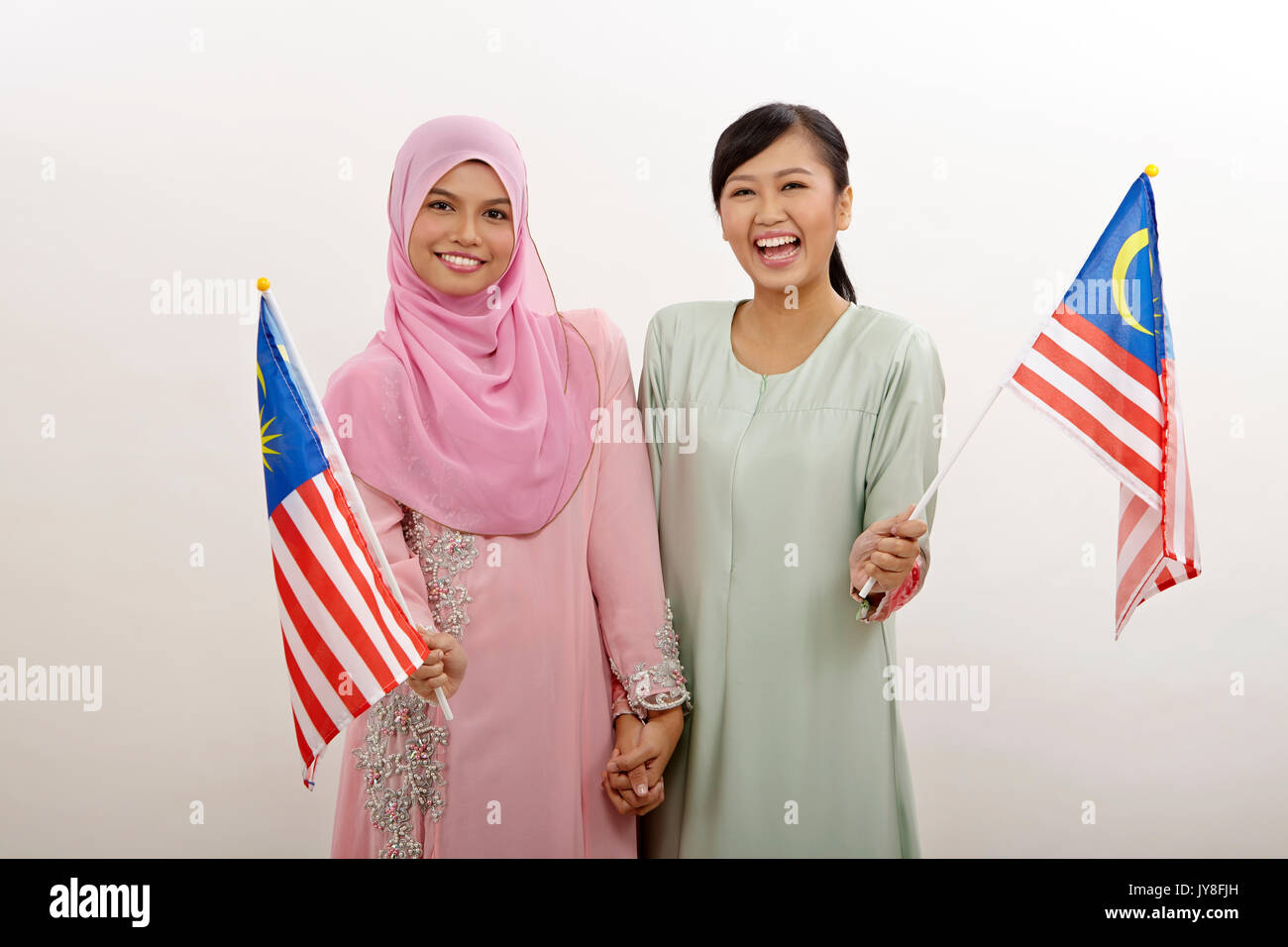 two malay women holding malaysia flag Stock Photo - Alamy