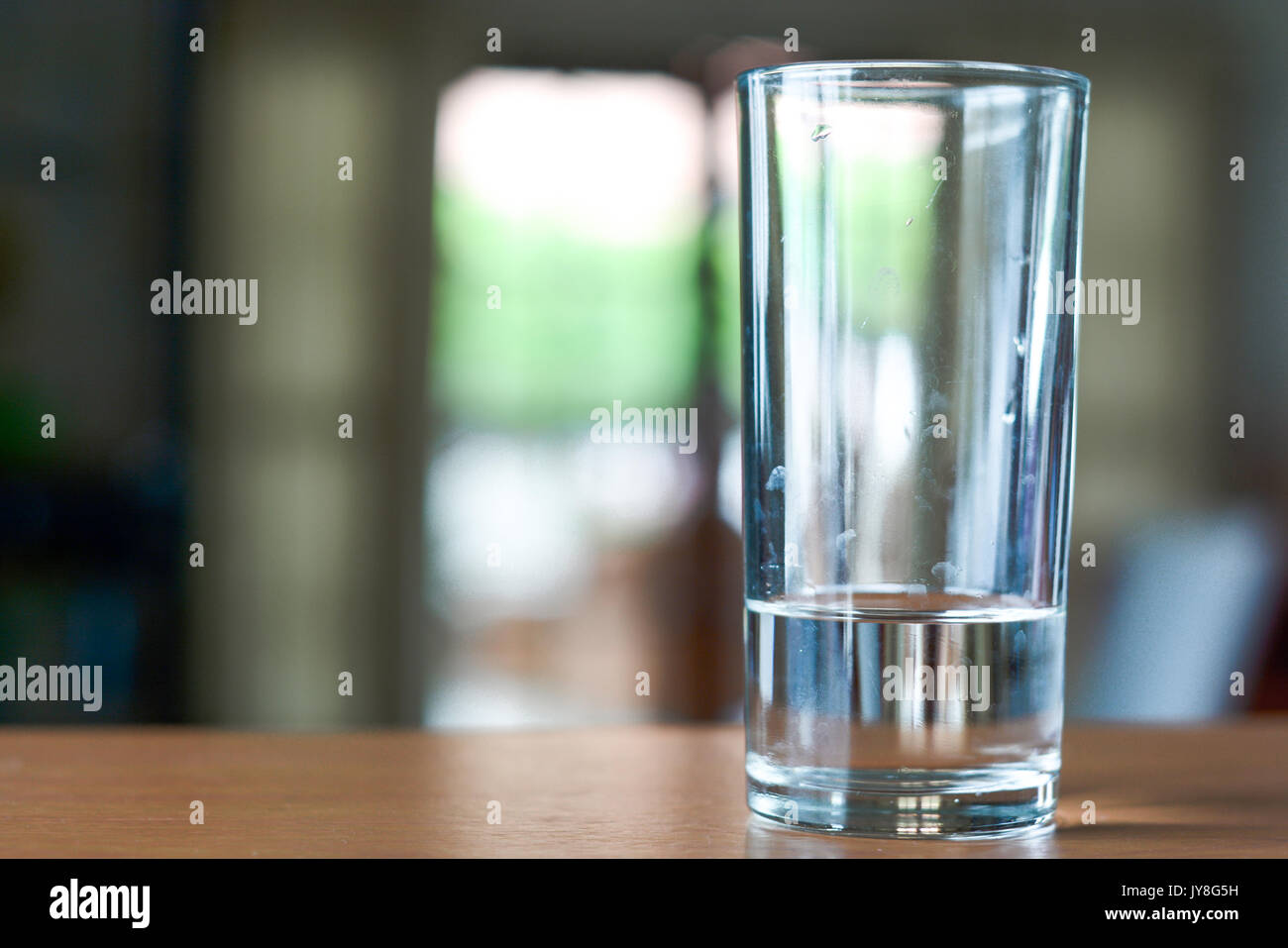 Glass of water on a wooden desk and living room background Stock Photo ...