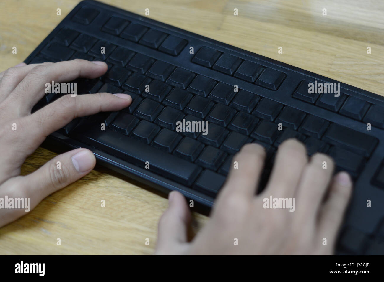 hands type on keyboard with wooden table Stock Photo - Alamy