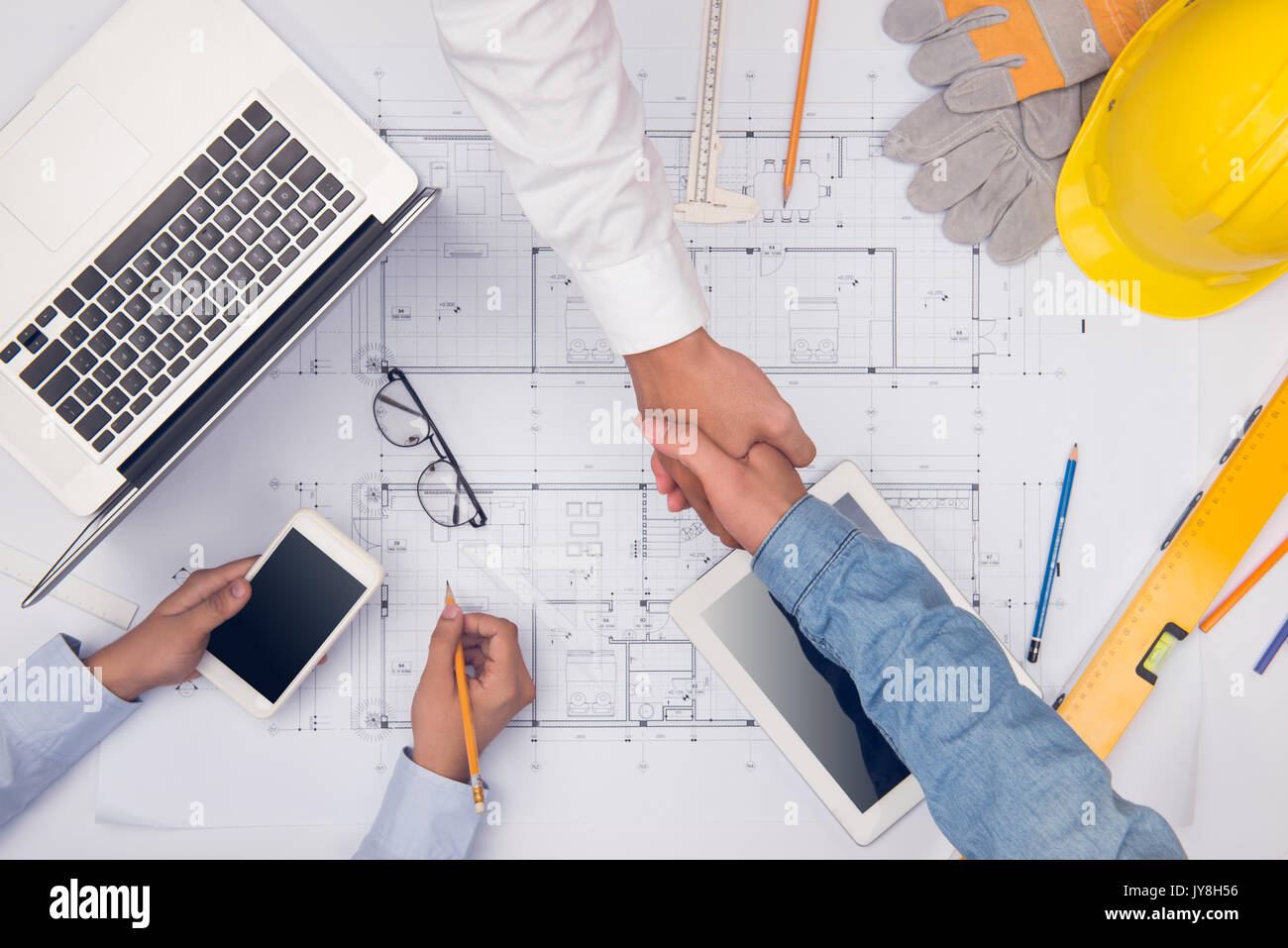 Hands of professional architects discussing and working with blueprints ...