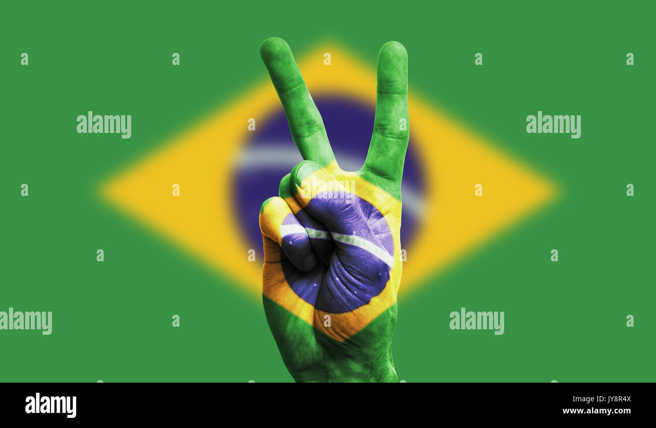 Brazil national flag painted onto a male hand showing a victory, peace ...