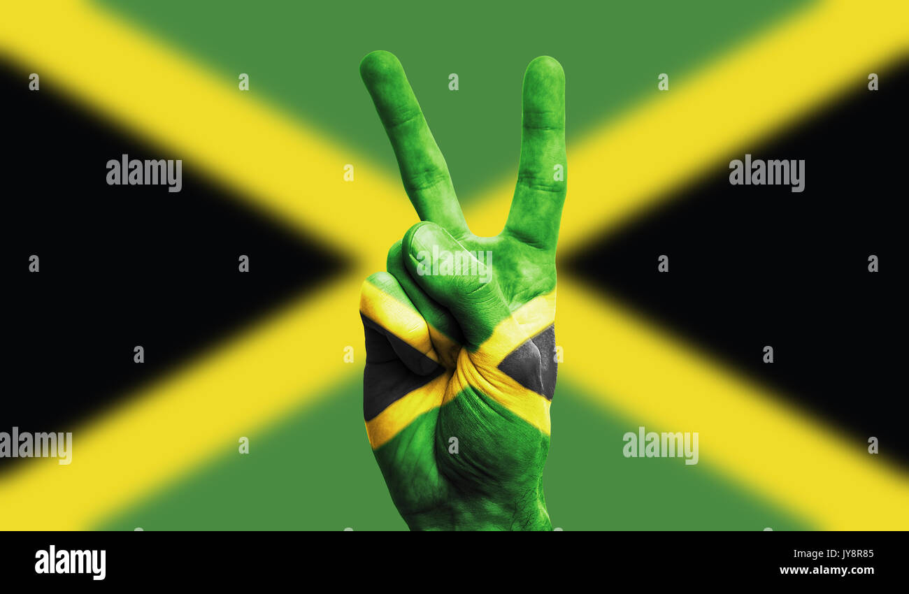 Jamaica national flag painted onto a male hand showing a victory, peace ...