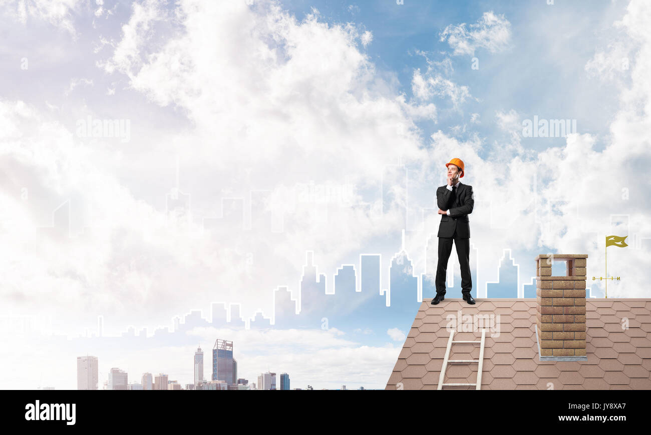 Engineer man standing on roof and looking away. Mixed media Stock Photo ...