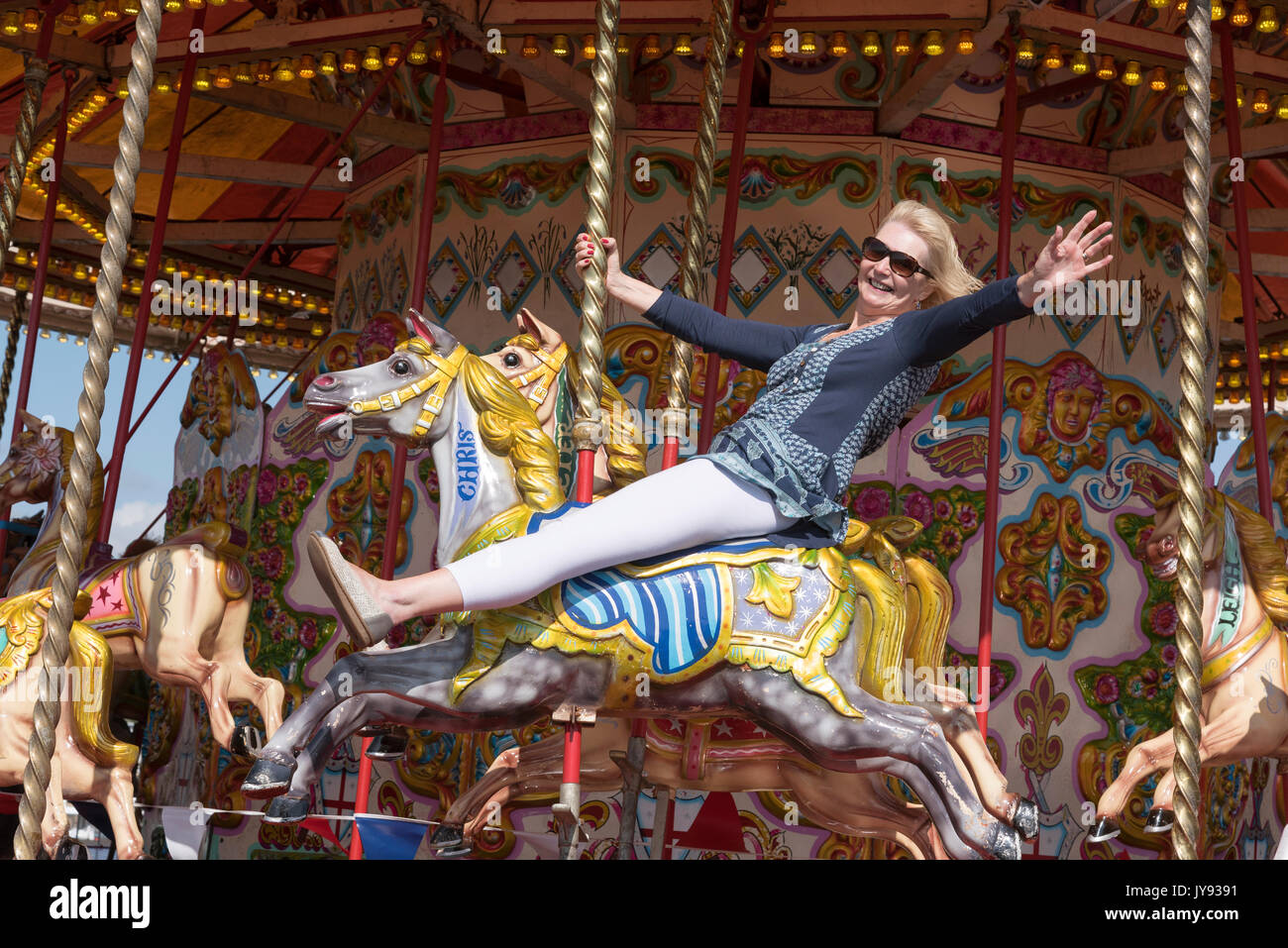 Woman riding a Carousel horse at the seaside Stock Photo - Alamy