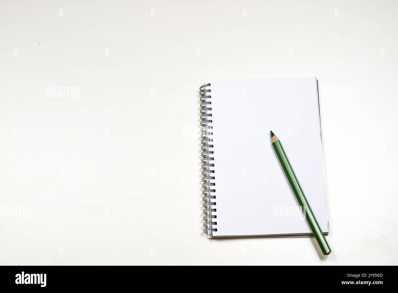 Sketchbook and crayons on a white table. White table and white ...