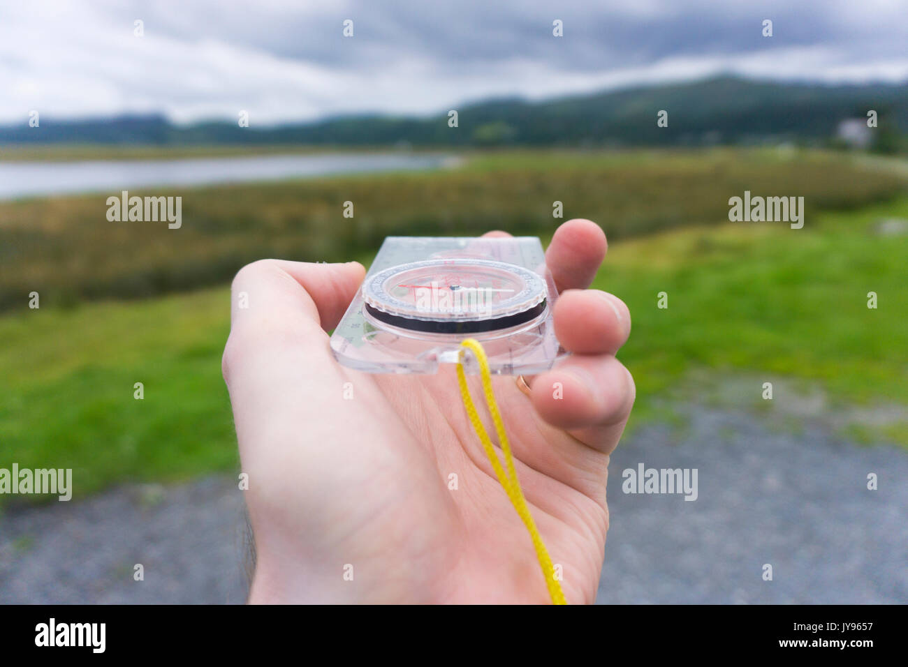 Male explorer with a compass in her hand. Point of view Stock Photo - Alamy
