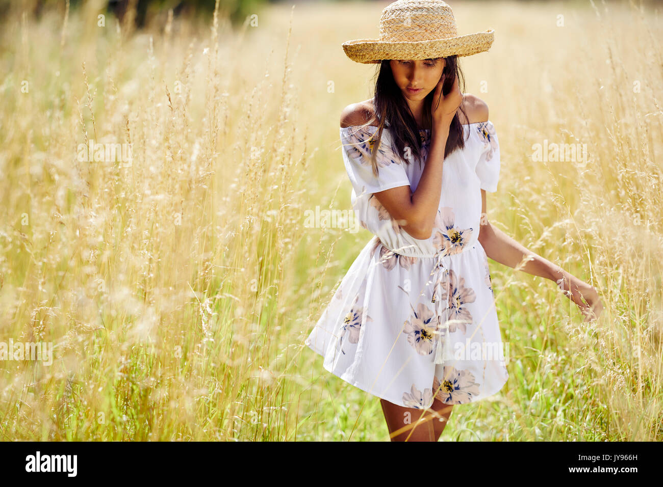 Beautiful girl walking in field Stock Photo - Alamy