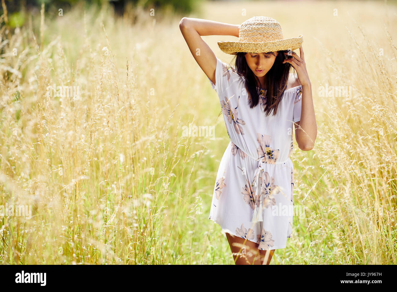 Beautiful girl walking in field Stock Photo - Alamy