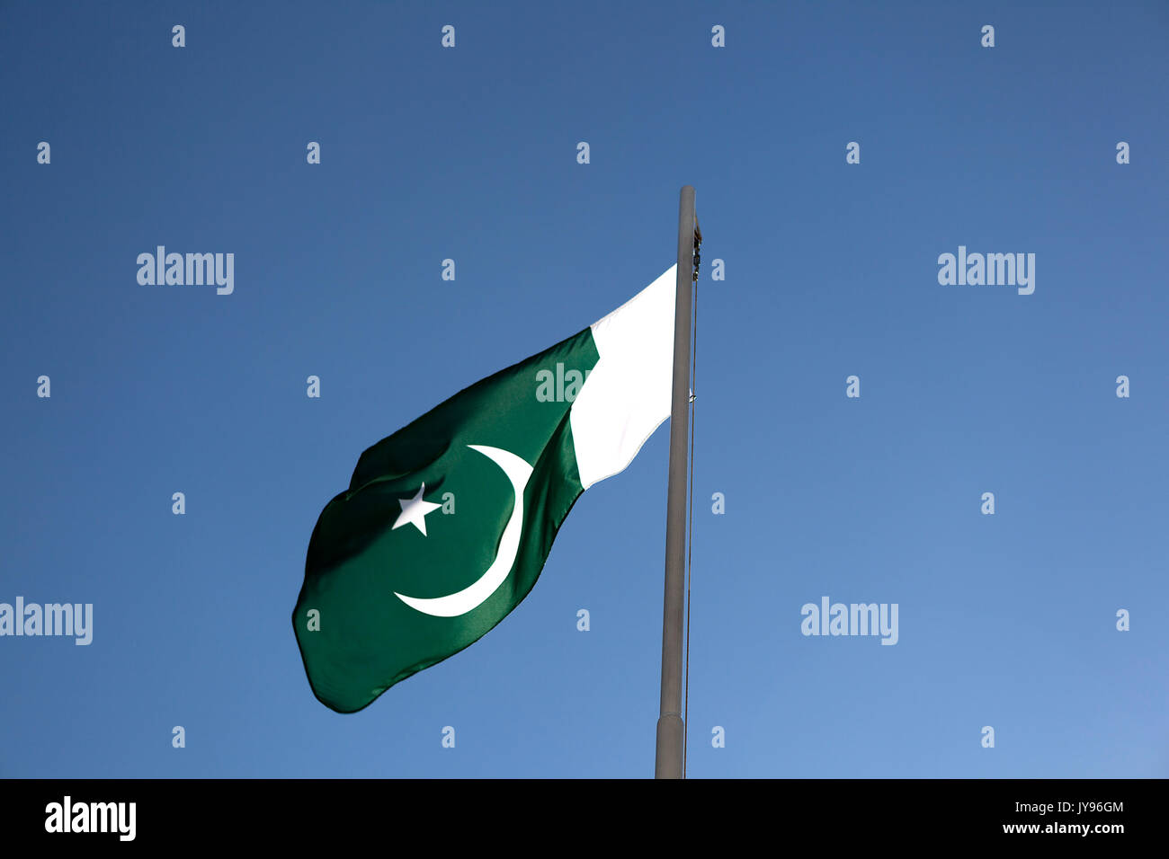 National flag of Pakistan on a flagpole in front of blue sky Stock ...