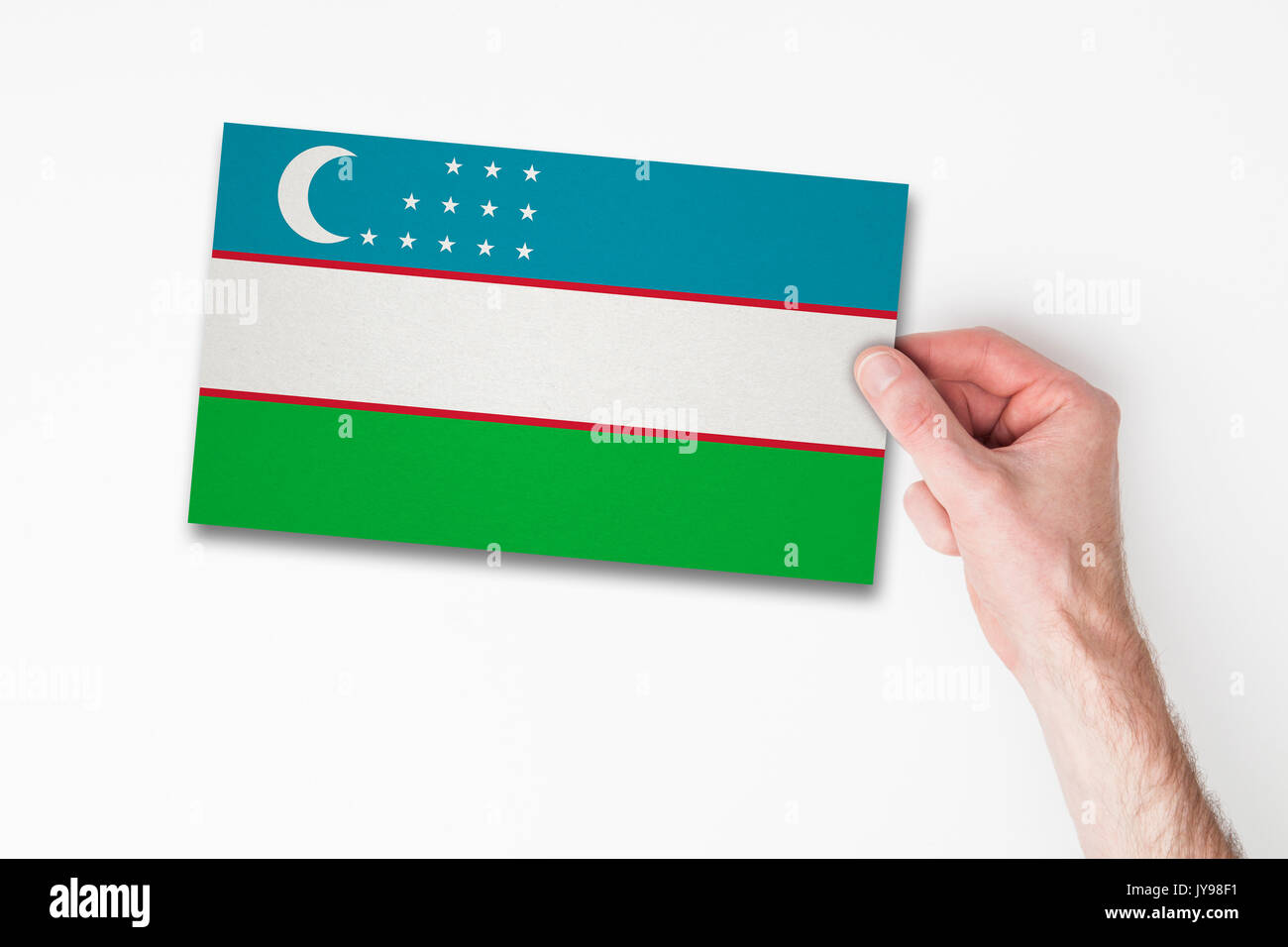 Male hand holding uzbekistan flag Stock Photo - Alamy