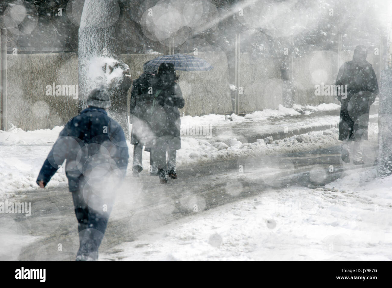 people walking on city street under snowing Stock Photo - Alamy