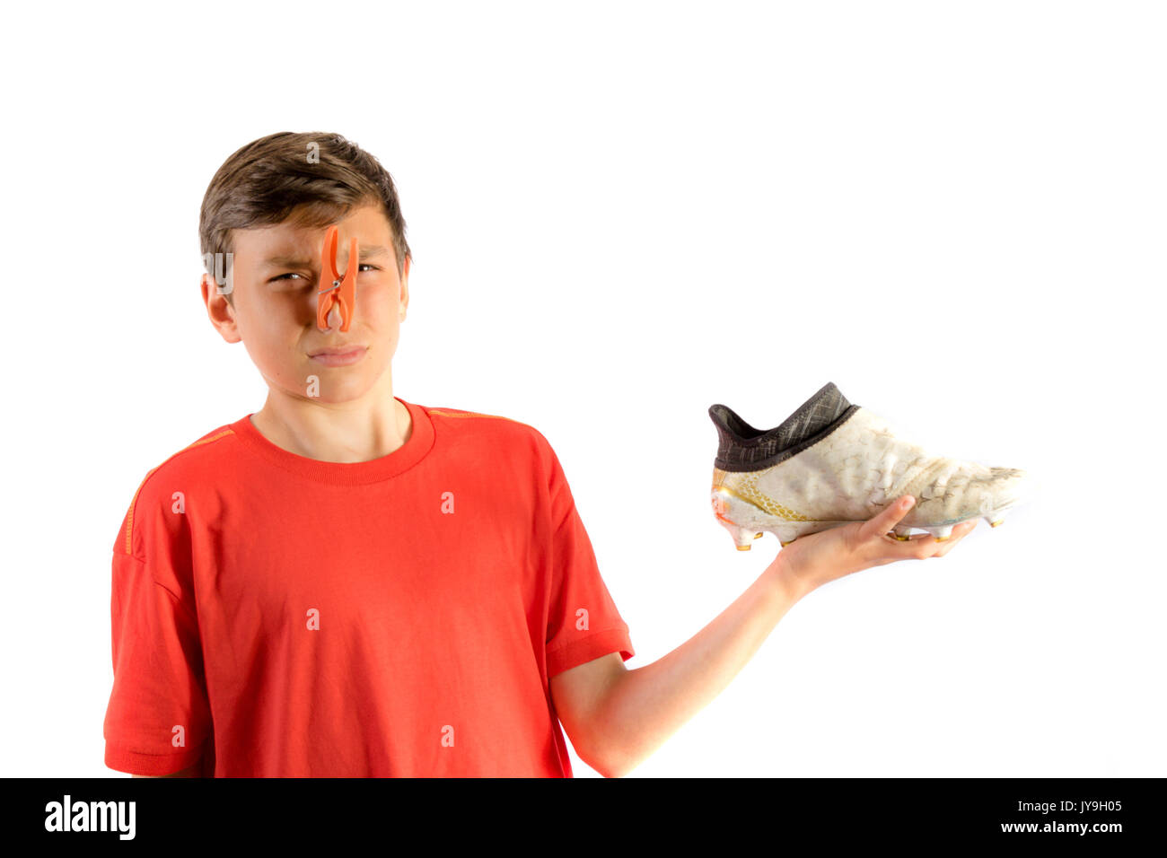 Young teenage boy isolated on a white background with a smelly football ...