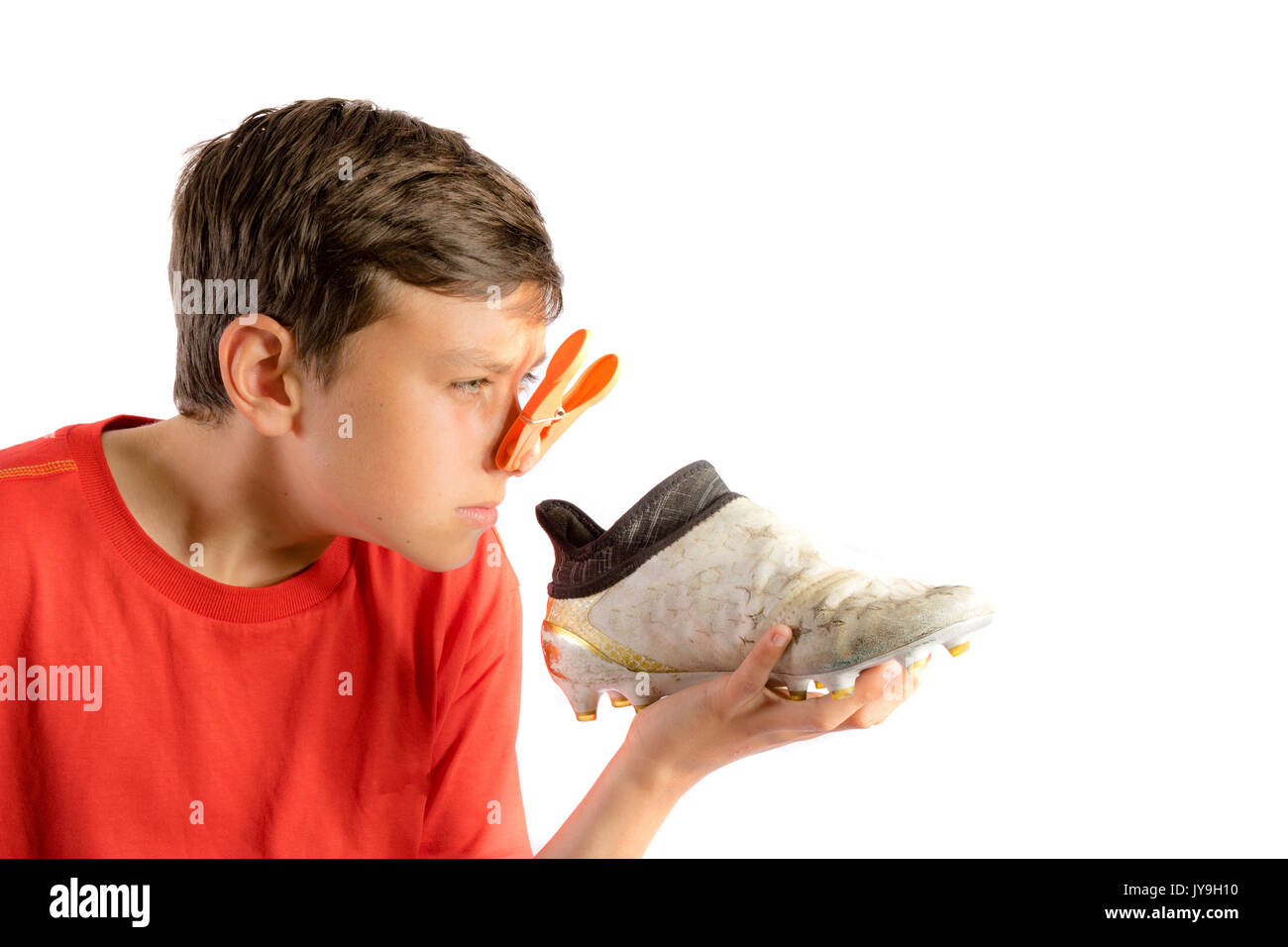 Young teenage boy isolated on a white background with a smelly football ...