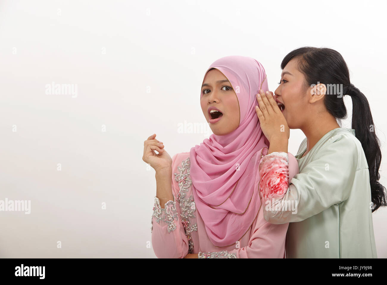Two teenage girls gossiping on the white background Stock Photo - Alamy