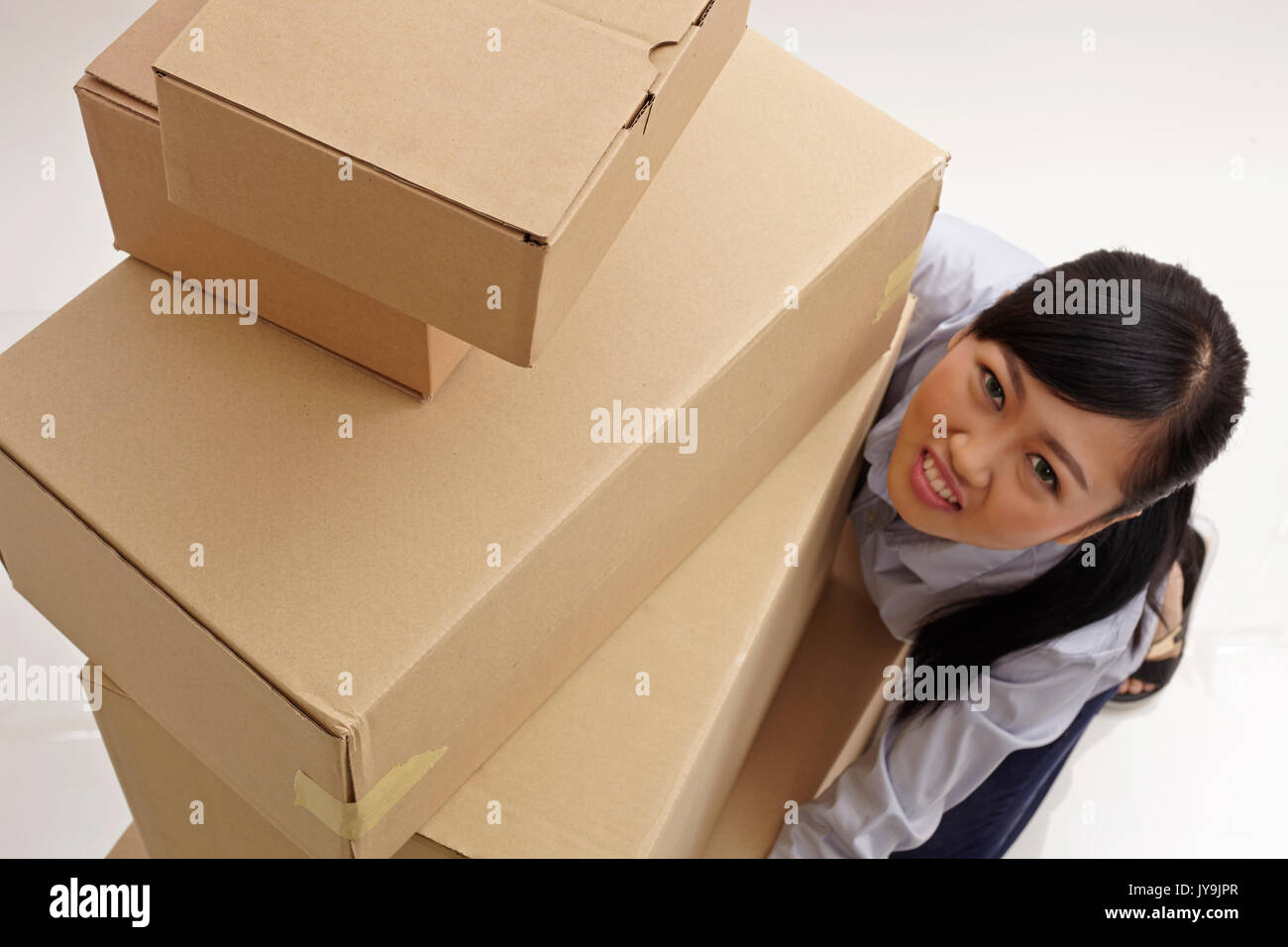 high angle view of asian woman lifting stack of boxes Stock Photo - Alamy