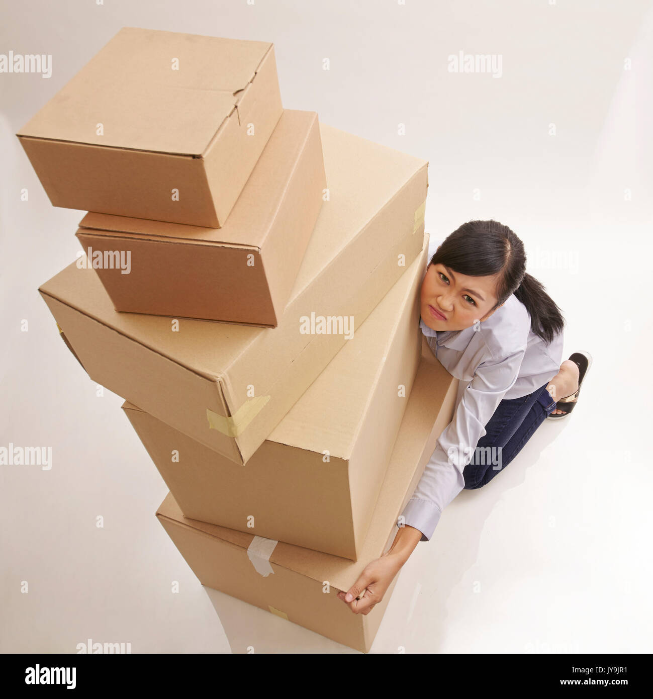 high angle view of asian woman lifting stack of boxes Stock Photo - Alamy