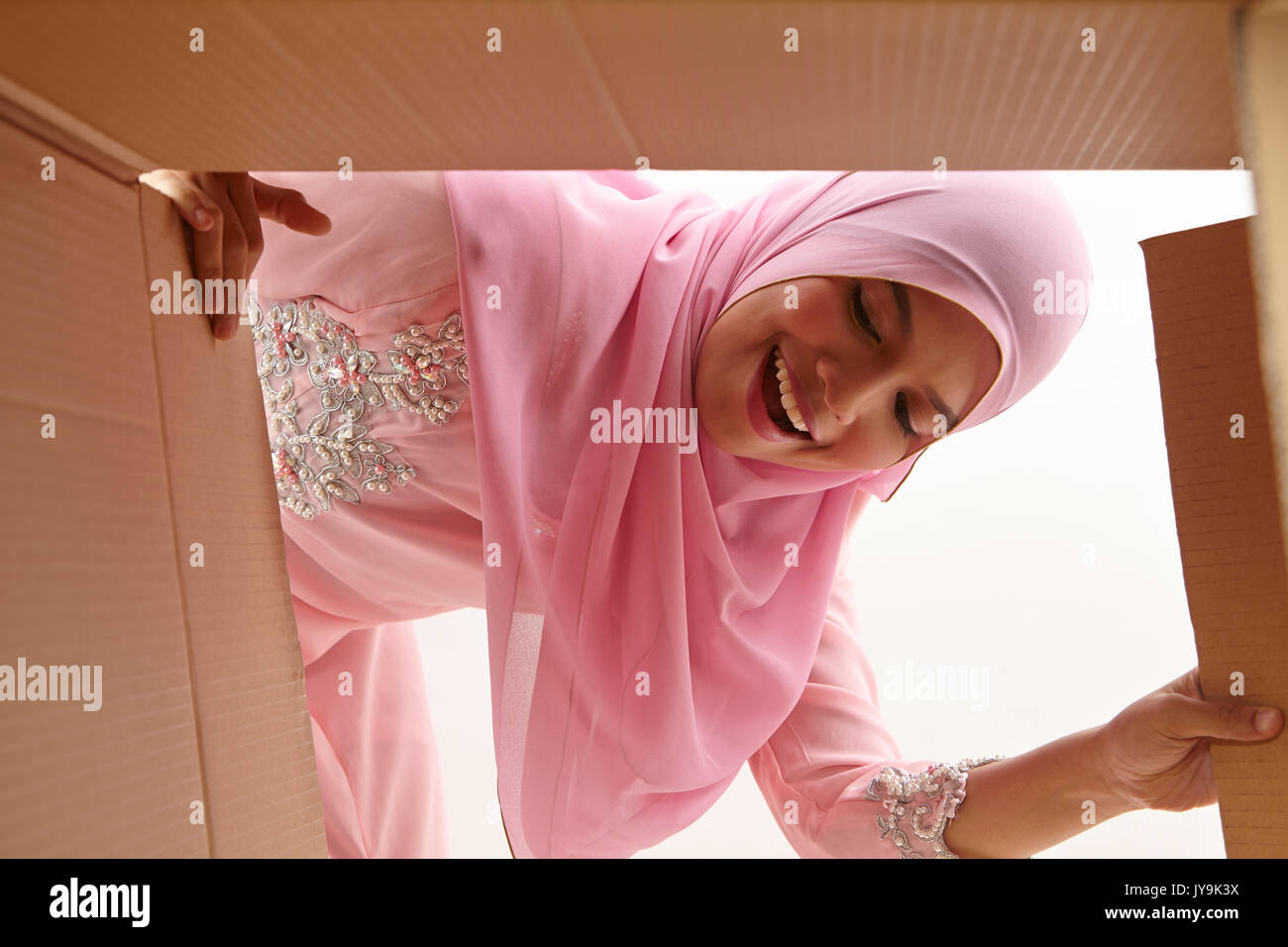 woman opening a carton box and looking inside, relocation and unpacking ...