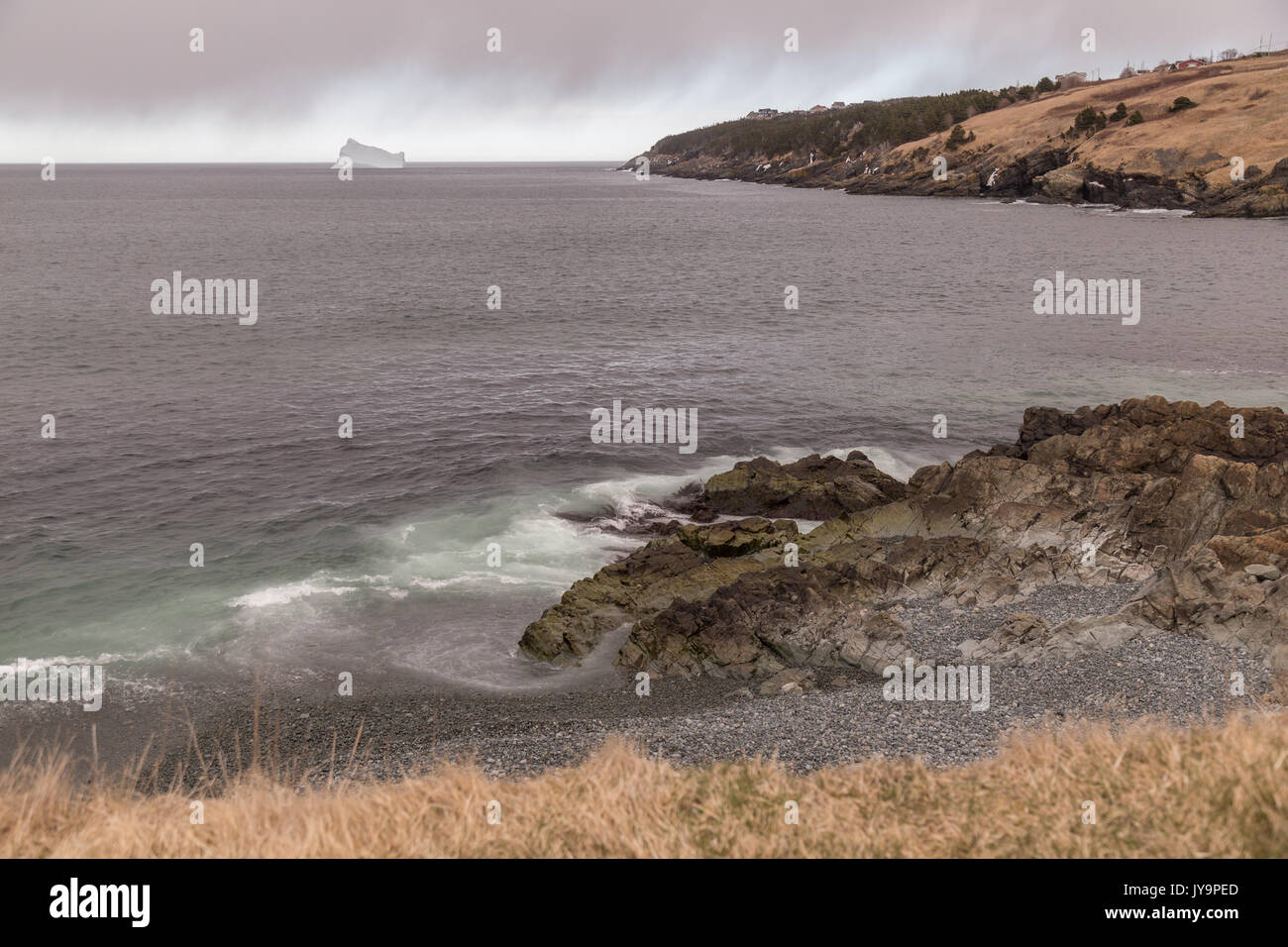 Large iceberg on the sea under storm clouds in Torbay, Newfoundland ...