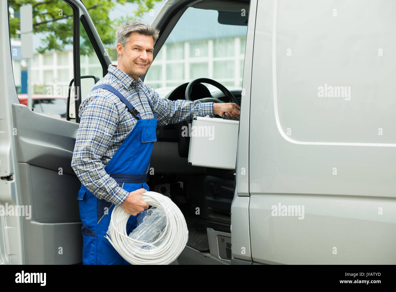 Happy Male Worker With Toolbox And Cable Coil Entering In Van Stock ...
