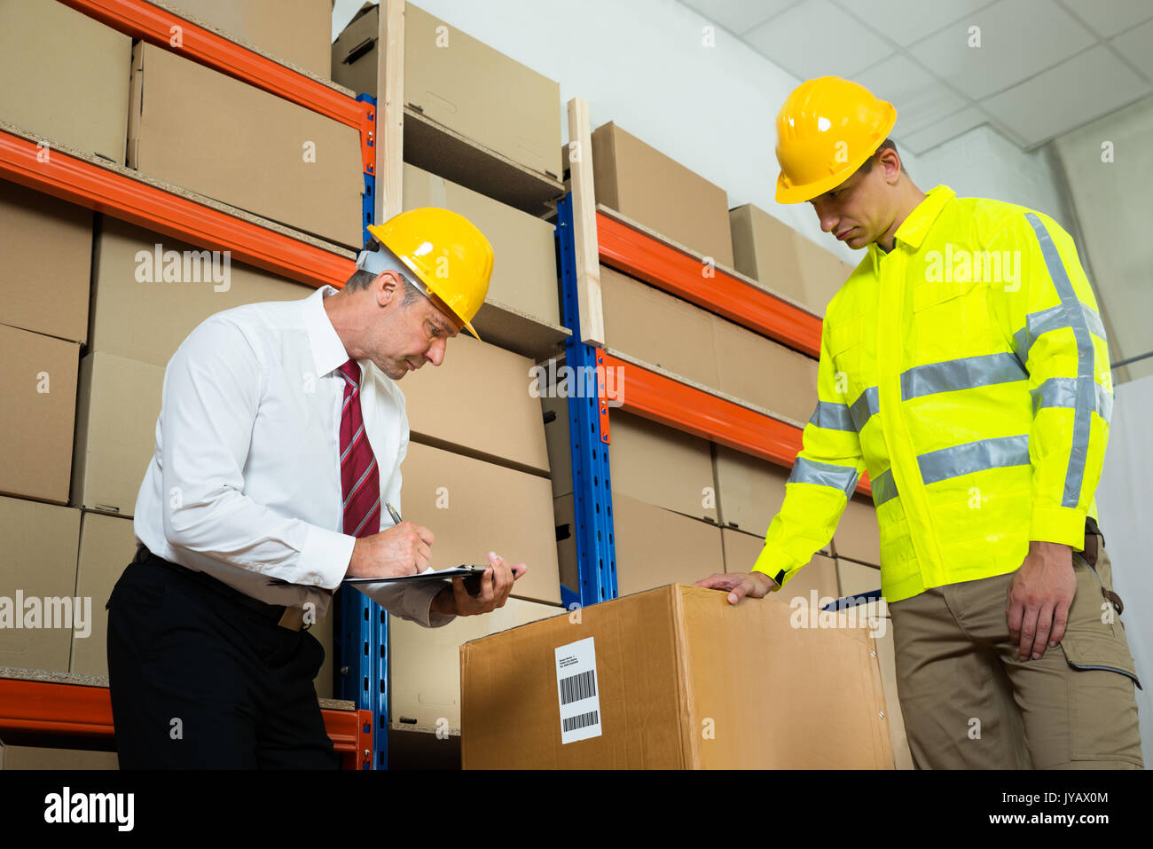 Manager Checking List While Worker Standing In Warehouse Stock Photo ...