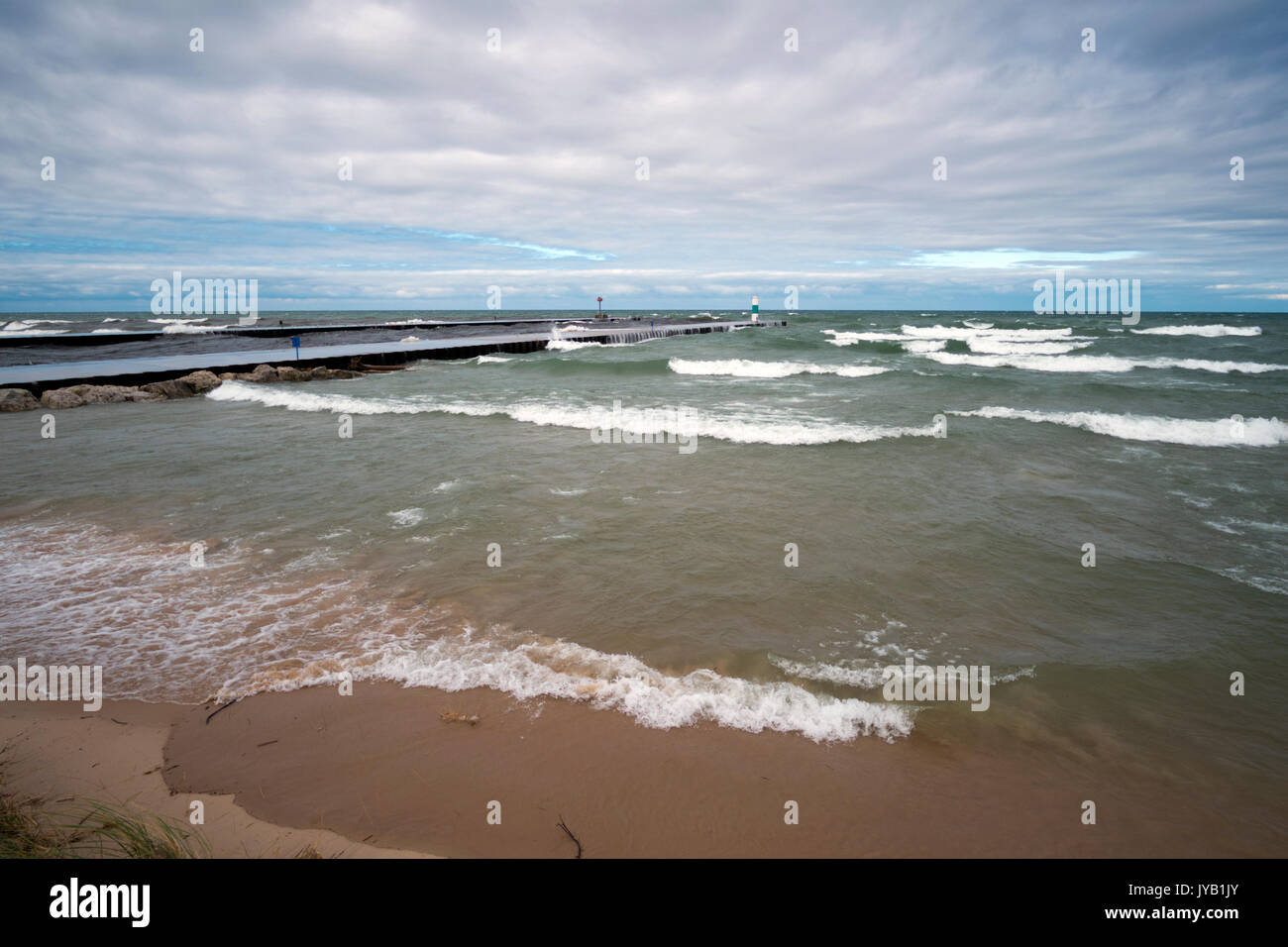 Waves crashing into the piers of the White Lake Channel and the beach ...