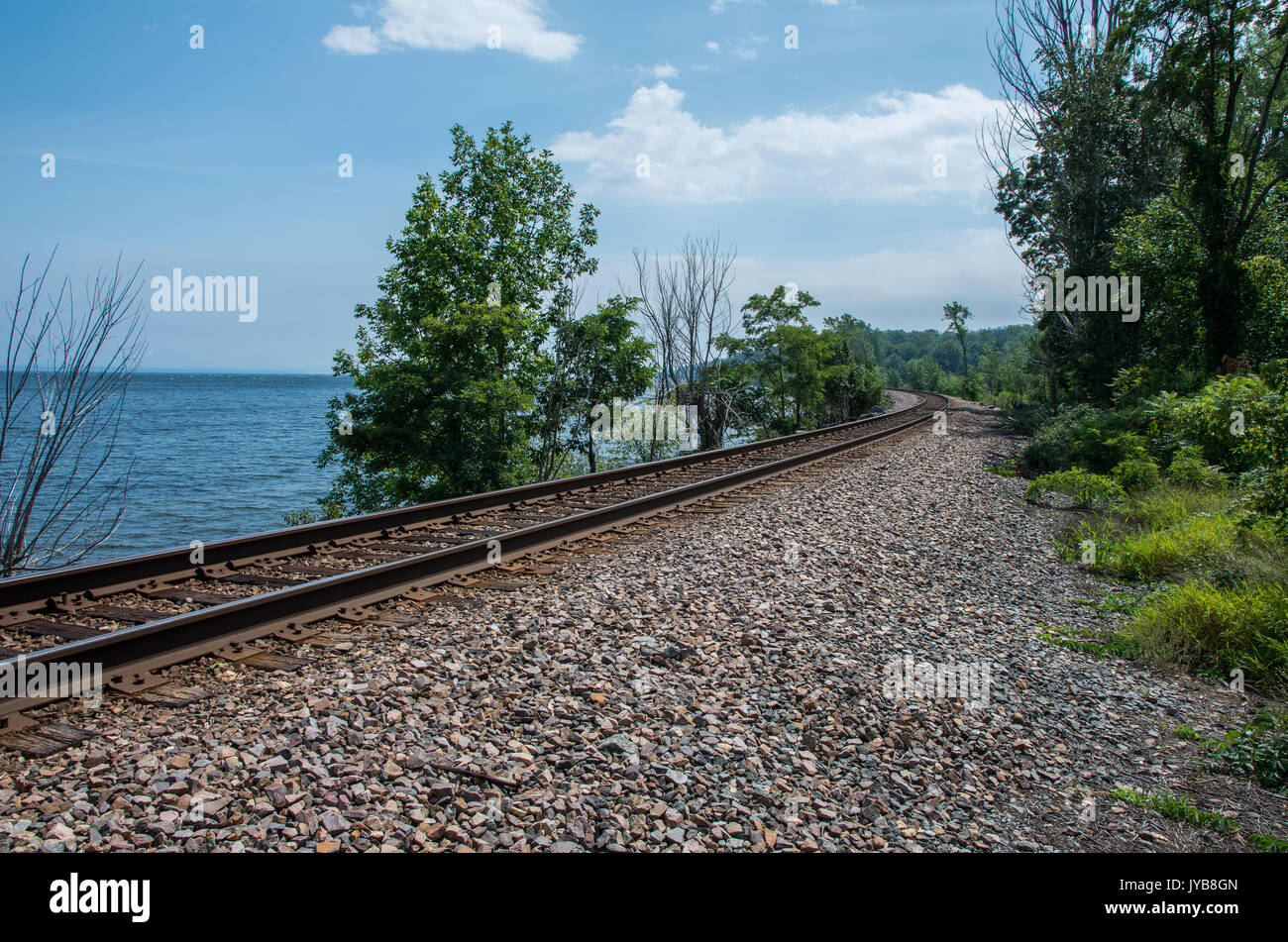 Railroad tracks on the edge of Lake Champlain with trees and crushed ...