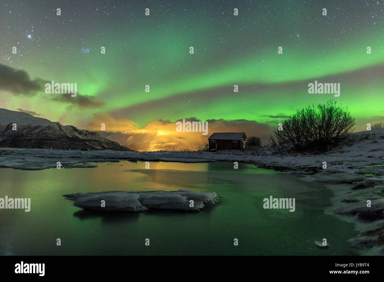 The Northern Lights illuminates the icy landscape in Svensby Lyngen ...