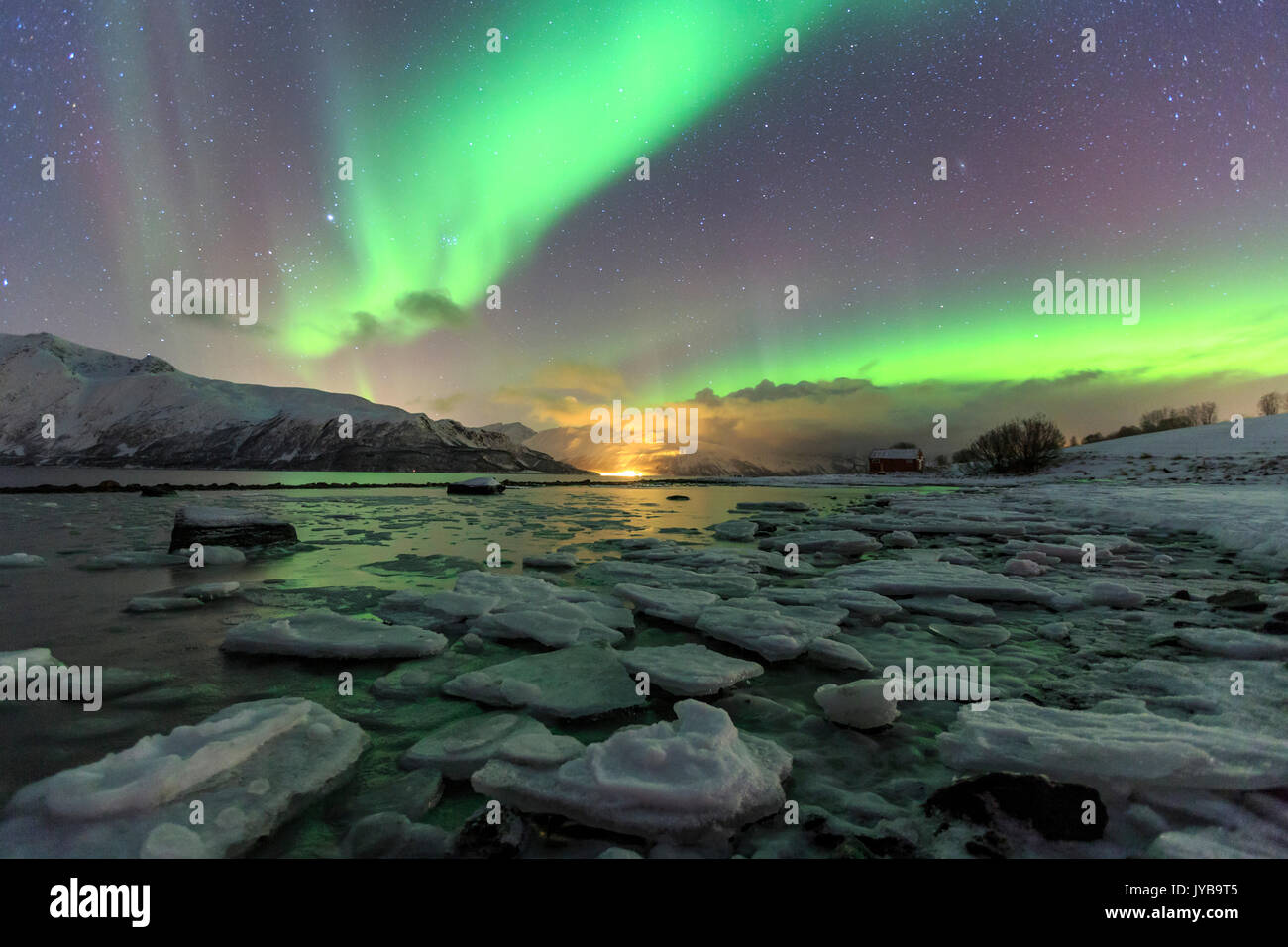 The Northern Lights illuminates the icy landscape in Svensby Lyngen ...
