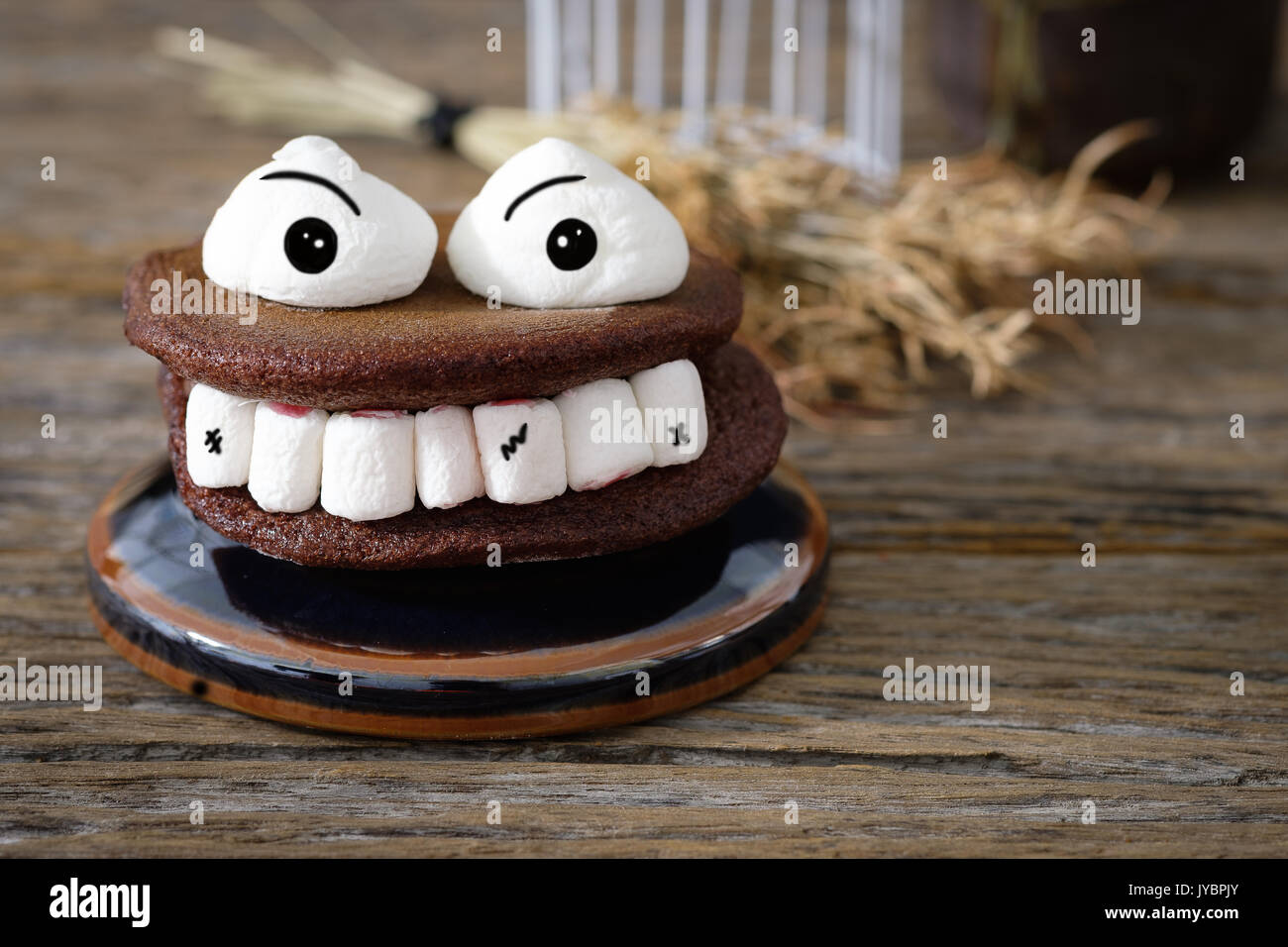 Halloween marshmallow and monster teeth smiling happily on a black ...