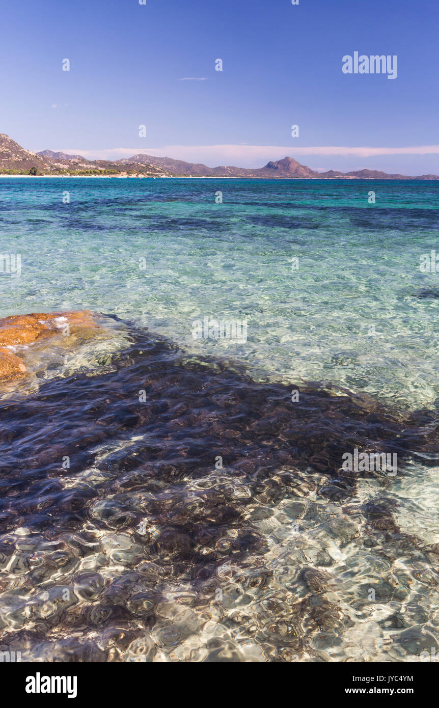 Rocks frame the turquoise water of sea around the sandy beach of Sant ...