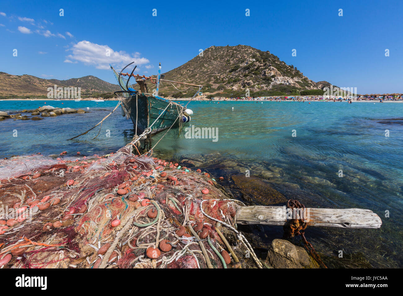 Fishing boat and nets in the turquoise sea surround the sandy beach ...