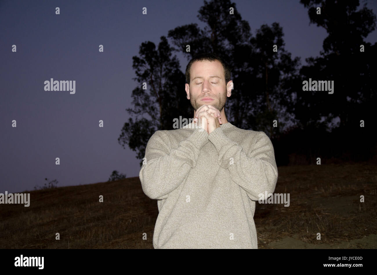 Man praying at nightfall Stock Photo - Alamy