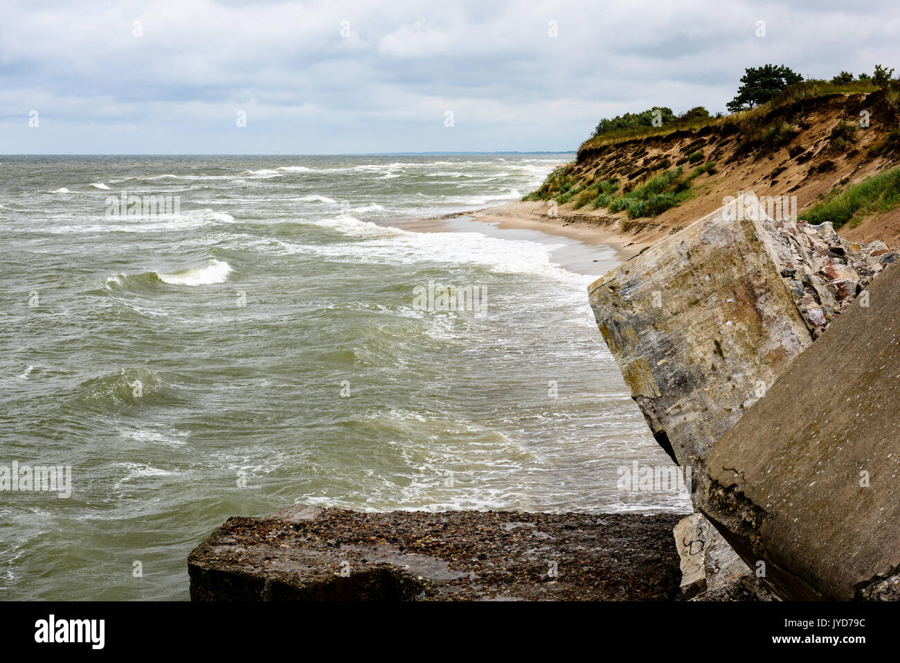 old war fort ruins on the beach with high waves in sunset. Liepaja ...
