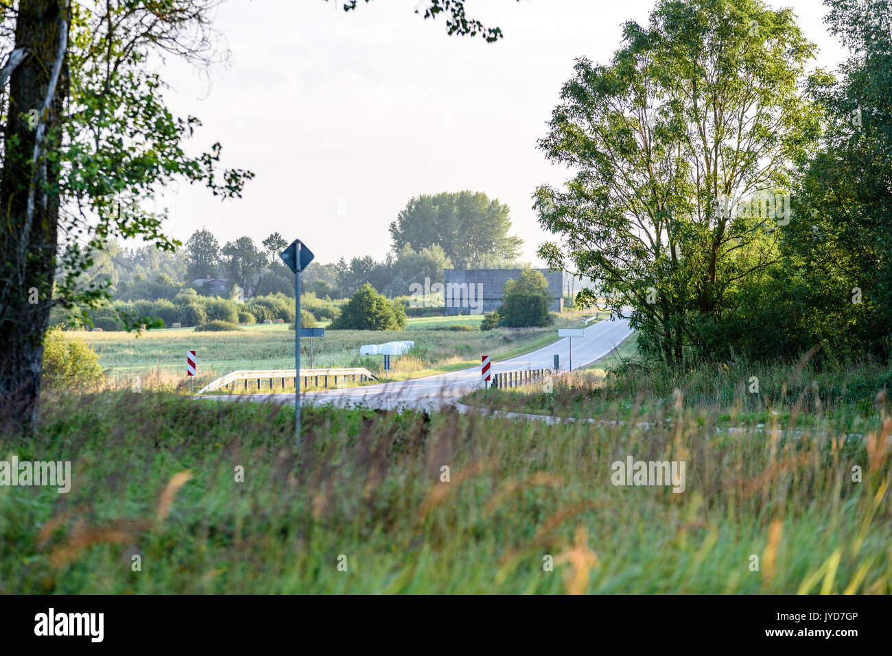 early morning in the countryside garden with fence and sun rays in ...