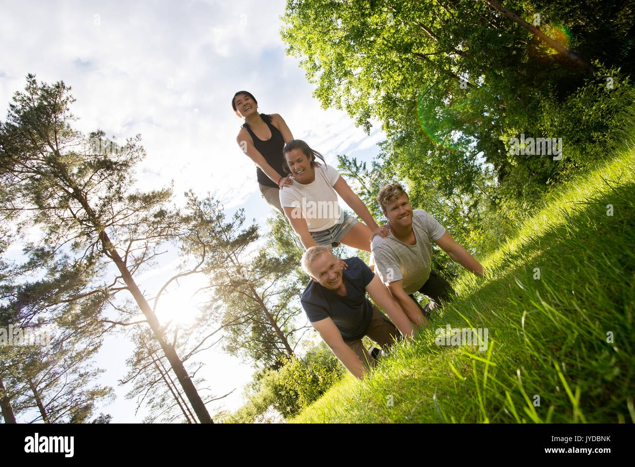 Tilt Image Of Confident Friends Making Human Pyramid On Field Stock ...