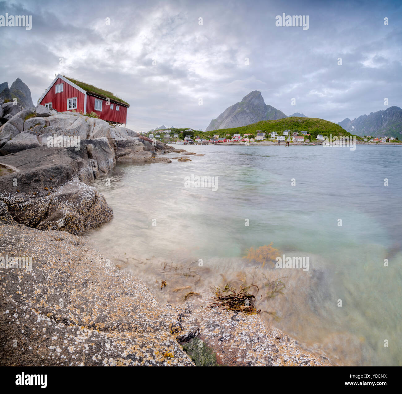 Panoramic of the typical Rorbu surrounded by peaks and clear sea Reine ...