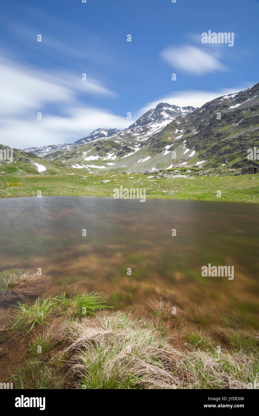 Lake Emet surrounded by green meadows and peaks Montespluga Chiavenna ...