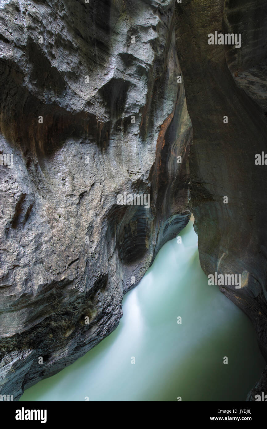 Water of creek flows in the narrow limestone gorge carved by river Aare ...