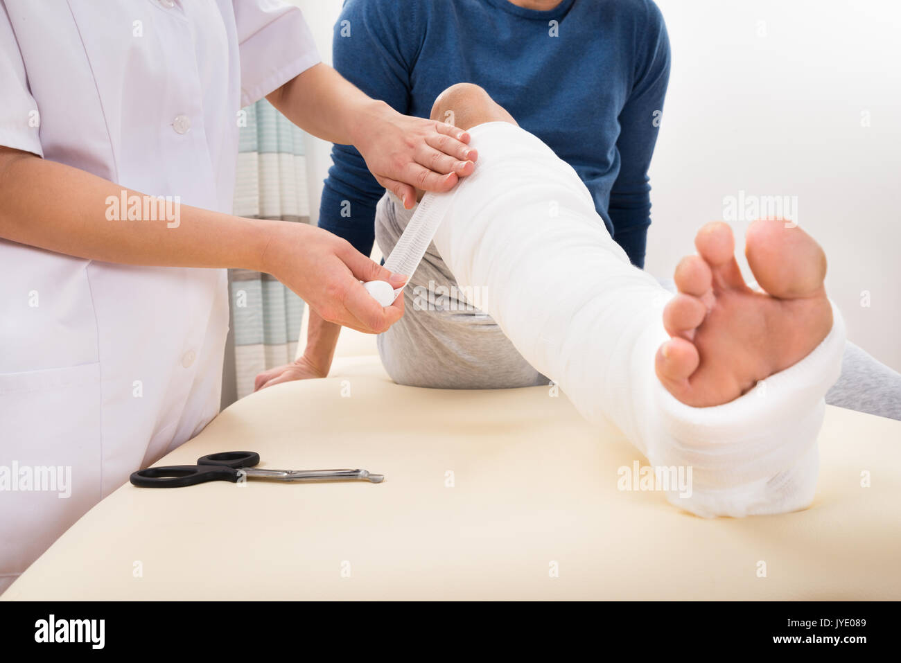 Close-up Of A Female Doctor Bandaging Patient's Leg Stock Photo - Alamy