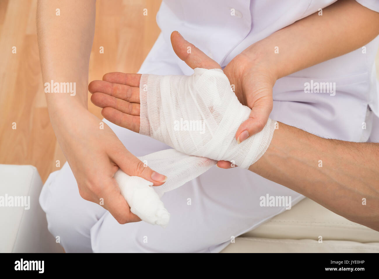 High Angle View Of A Female Doctor Bandaging Patient's Hand Stock Photo ...
