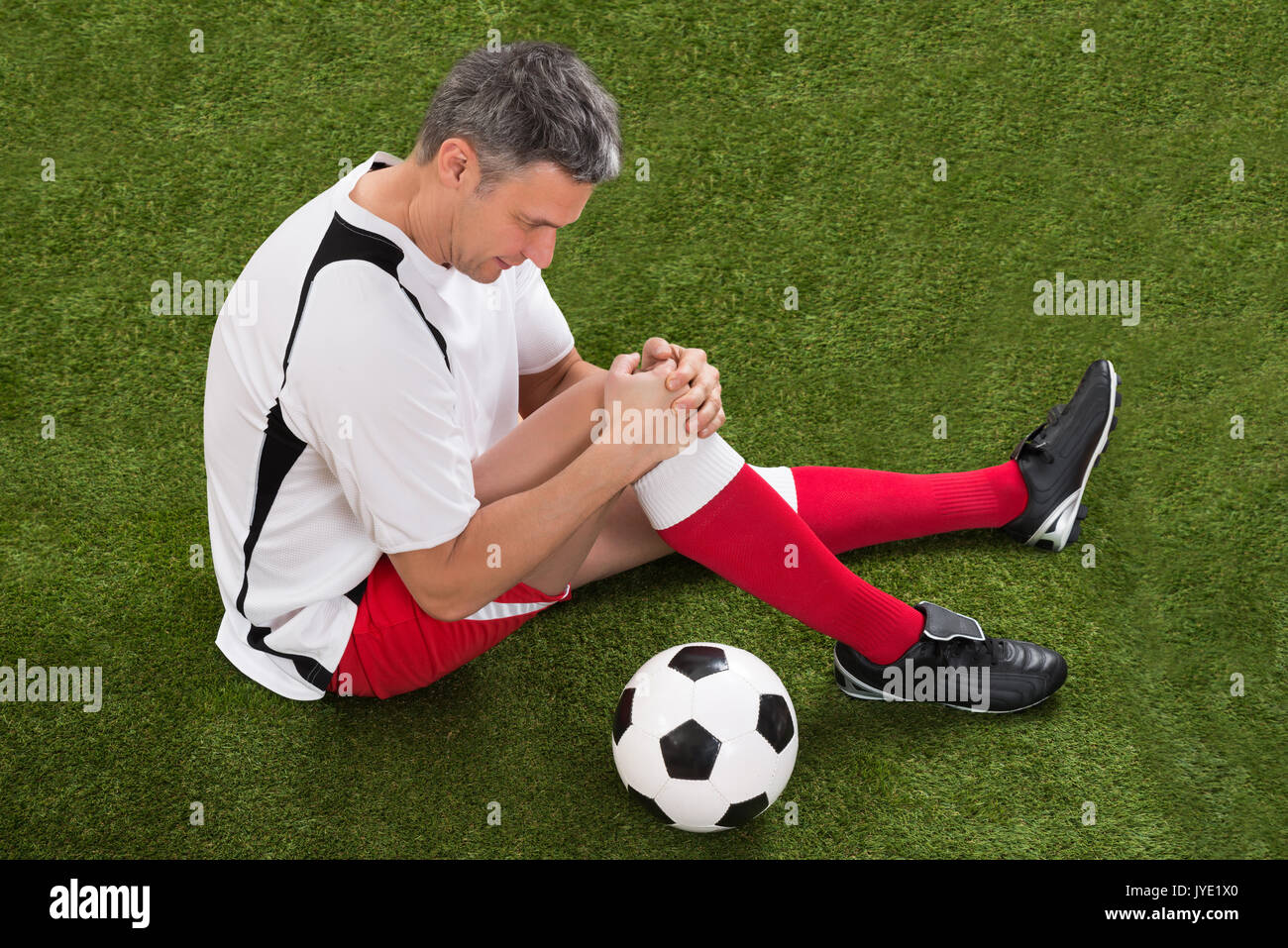 Male Soccer Player Suffering From Injury In Knee Stock Photo - Alamy