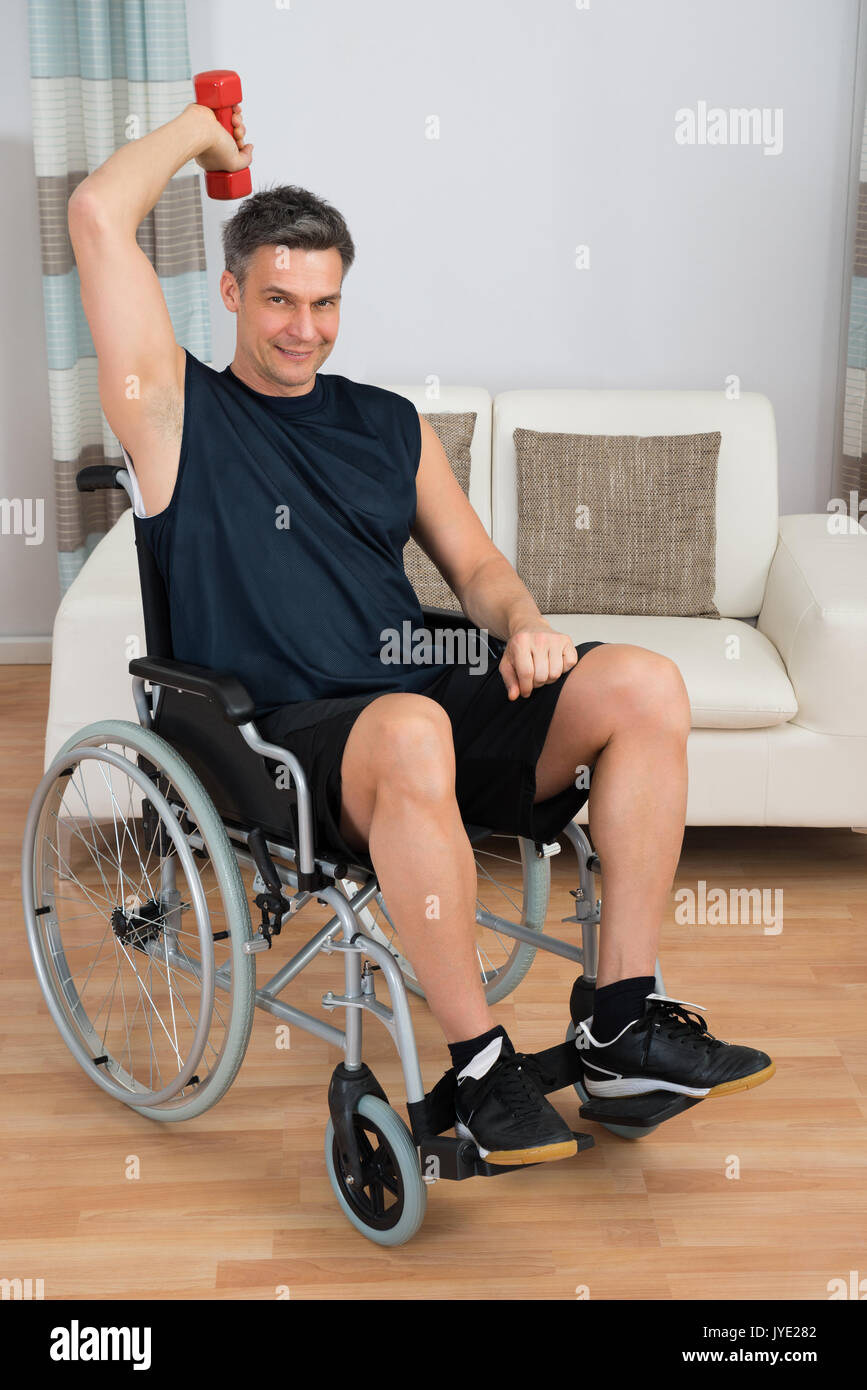 Handicapped Man On Wheelchair Working Out With Dumbbell At Home Stock ...