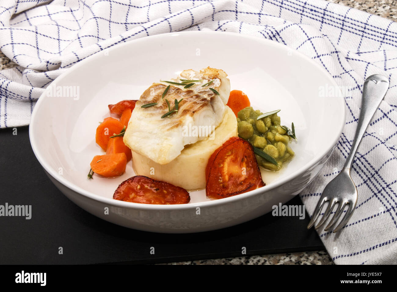 grilled cod with mashed potato, carrots, slice tomato and mushy pea ...
