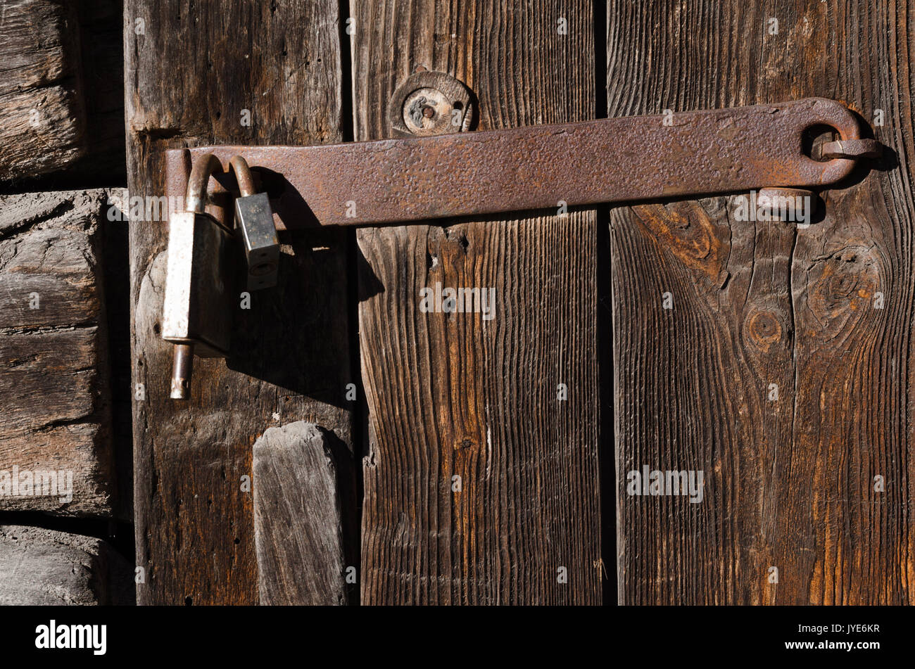 New metal lock on old iron fixture hanging on wooden boards, texture ...