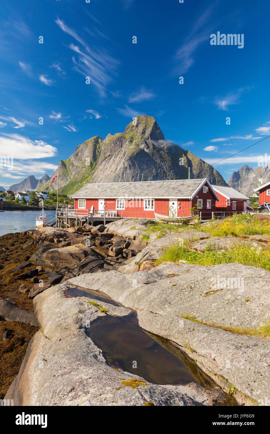 Typical houses of fishermen called Rorbu framed by rocky peaks and blue ...