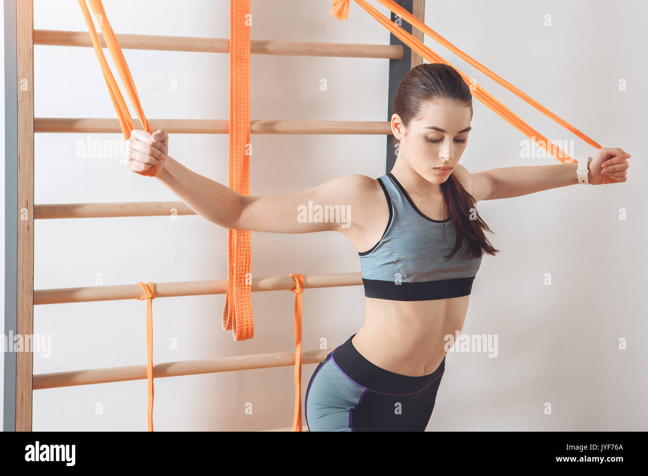 Female training in gym body workout pull ropes Stock Photo - Alamy