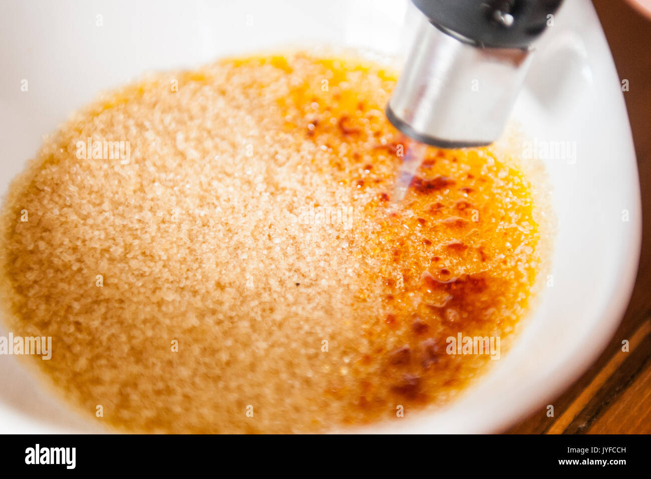 A chef burns brown sugar for a creme brulee Stock Photo - Alamy