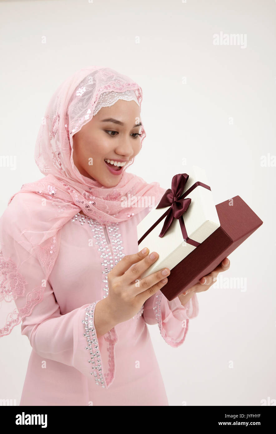 malay woman with tudung holding a present Stock Photo - Alamy