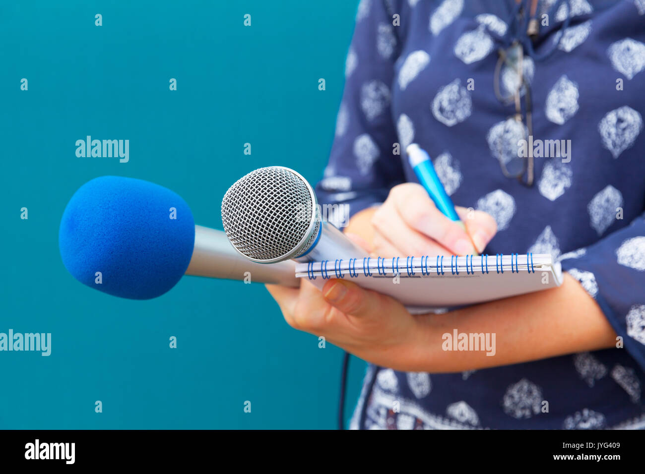 Female reporter taking notes at news conference Stock Photo - Alamy